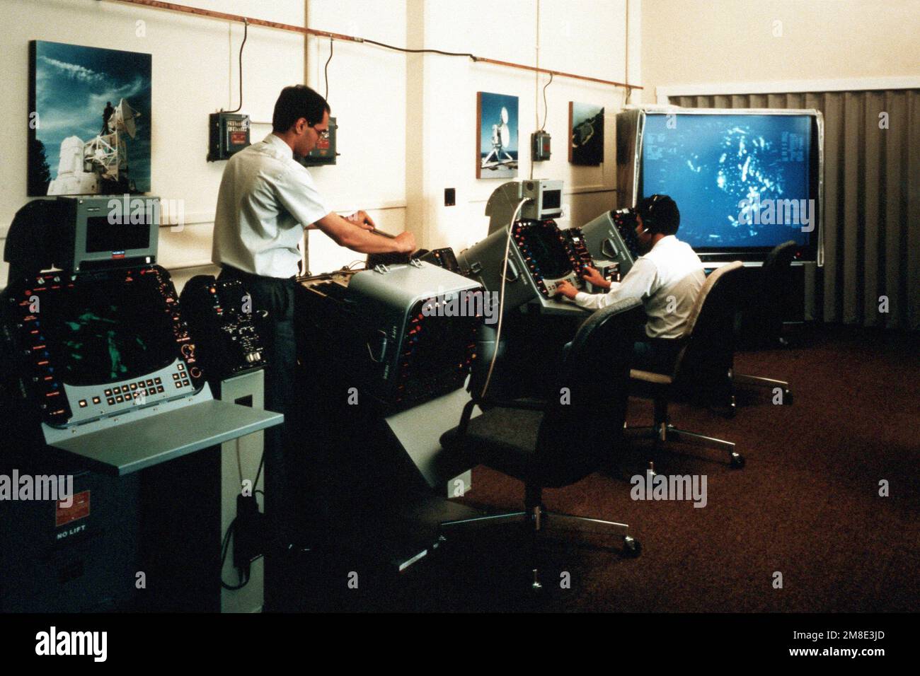 A technician replaces a printed circuit board in a display console for ...