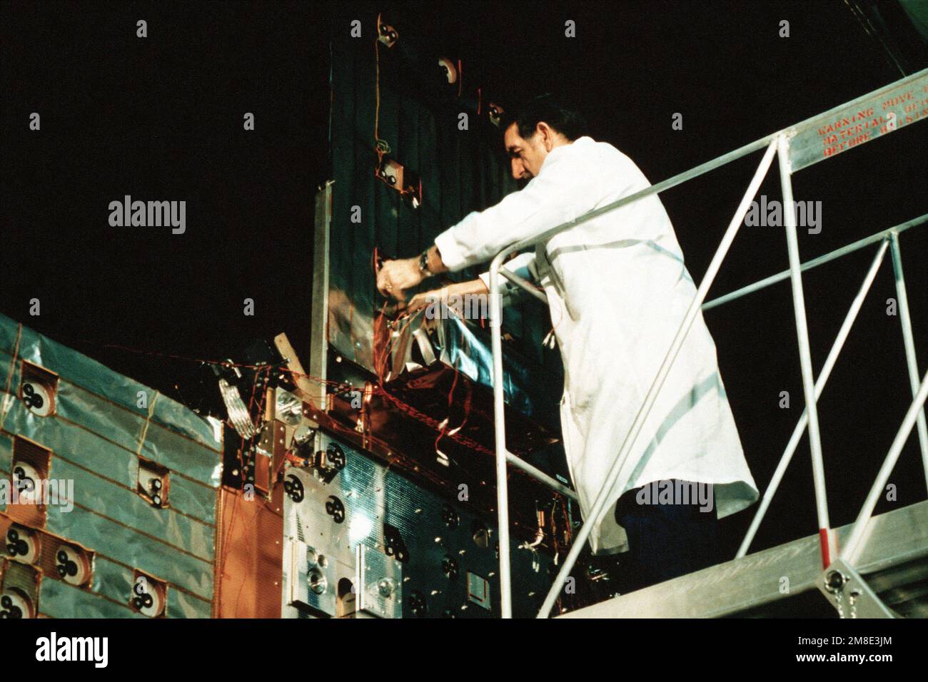 A technician at the Naval Research Laboratory (NRL) connects wires on ...