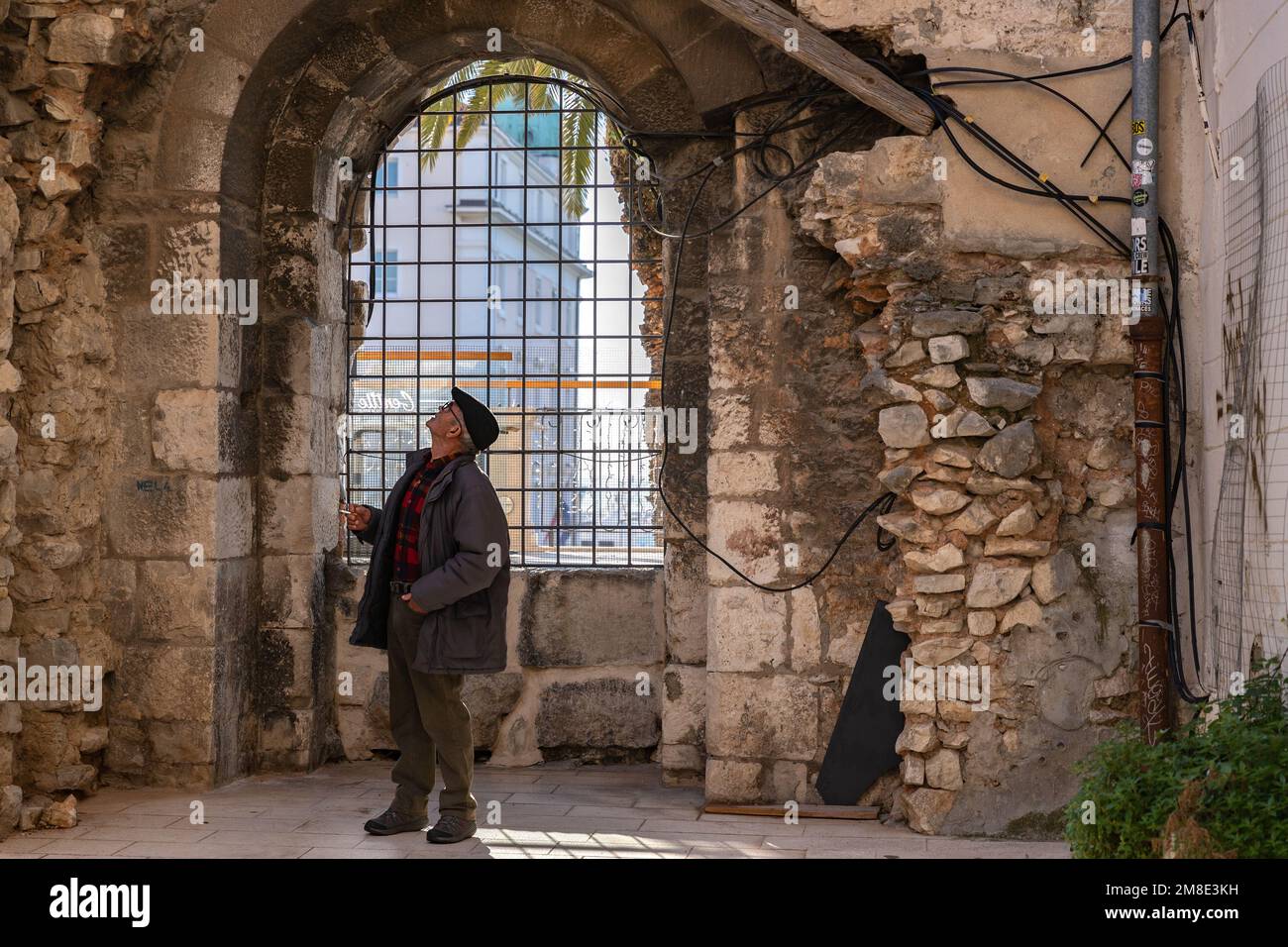 Man walking in the old town of Split. Man looking on the ancient walls ...
