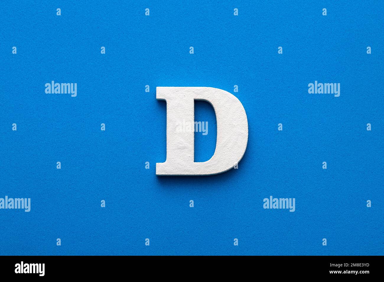 Alphabet letter D - White wooden letter on blue foamy background Stock ...