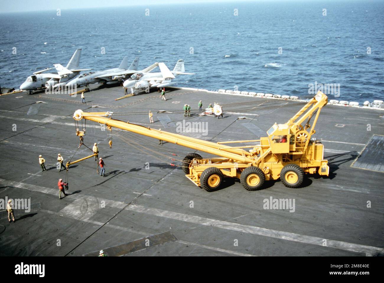 The crash crane is moved into position on the flight deck of the ...