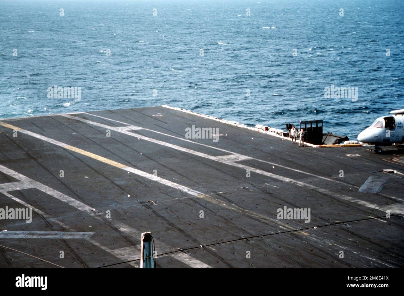 Fragments on the nylon crash barricade are blown along the flight deck ...