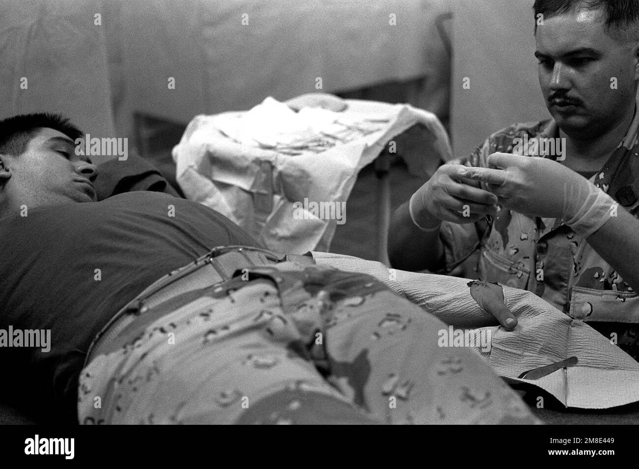 Hospital Corpsman 2nd Class Akers, Headquarters Battalion, stitches a ...