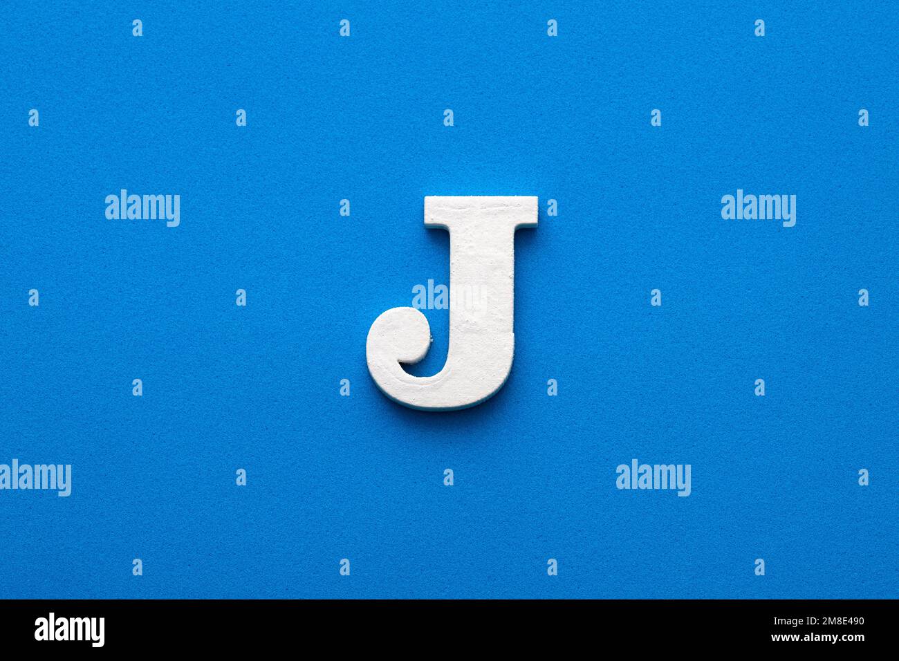 Alphabet letter J - White wooden letter on blue foamy background Stock ...