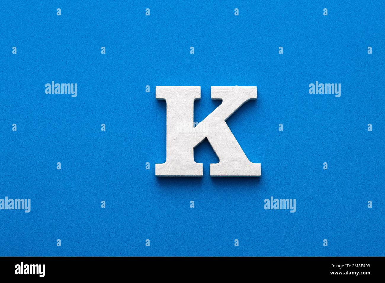 Letter K uppercase - White wood font on blue foamy background Stock ...