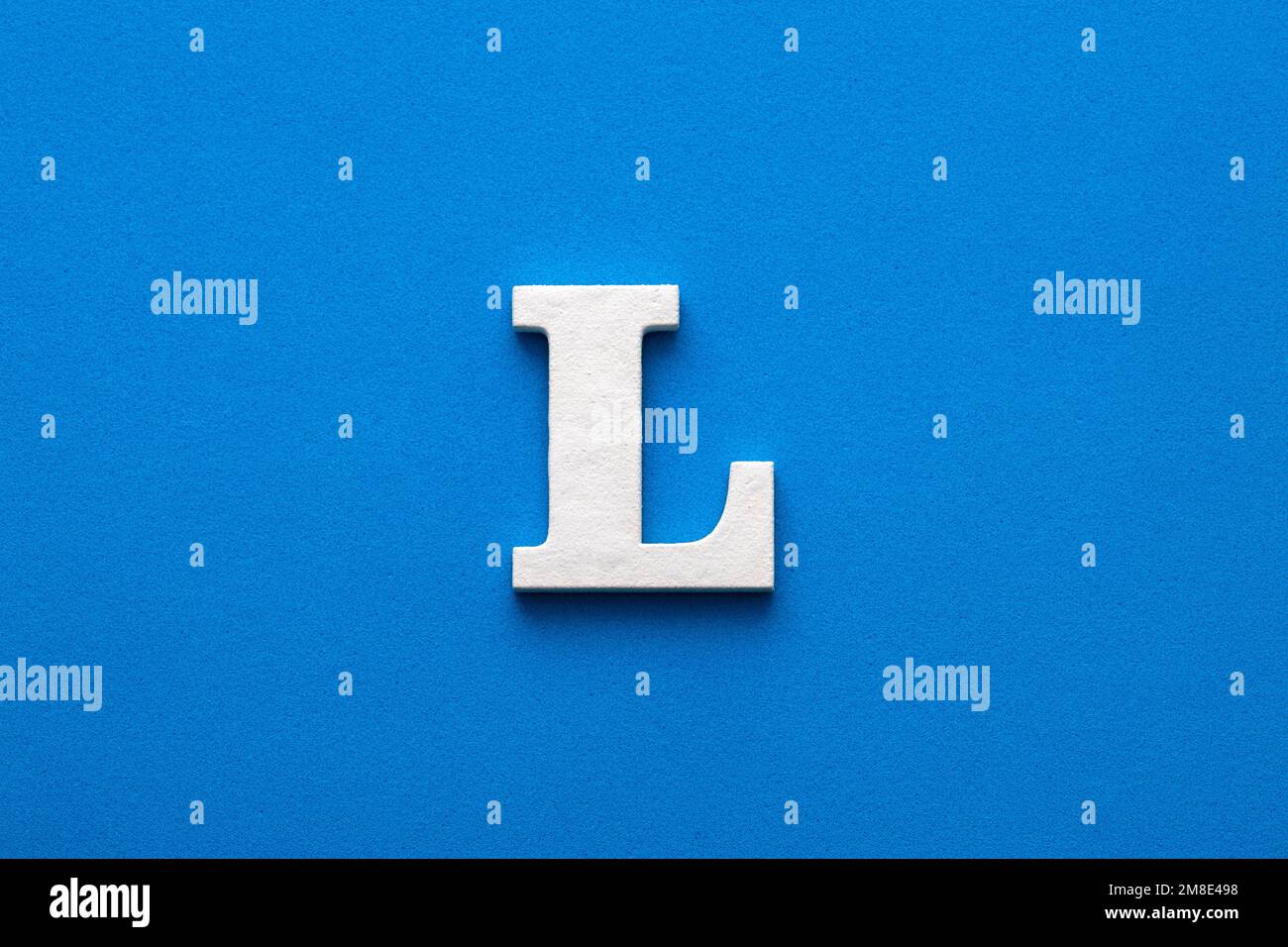 Alphabet letter L - White wooden letter on blue foamy background Stock ...