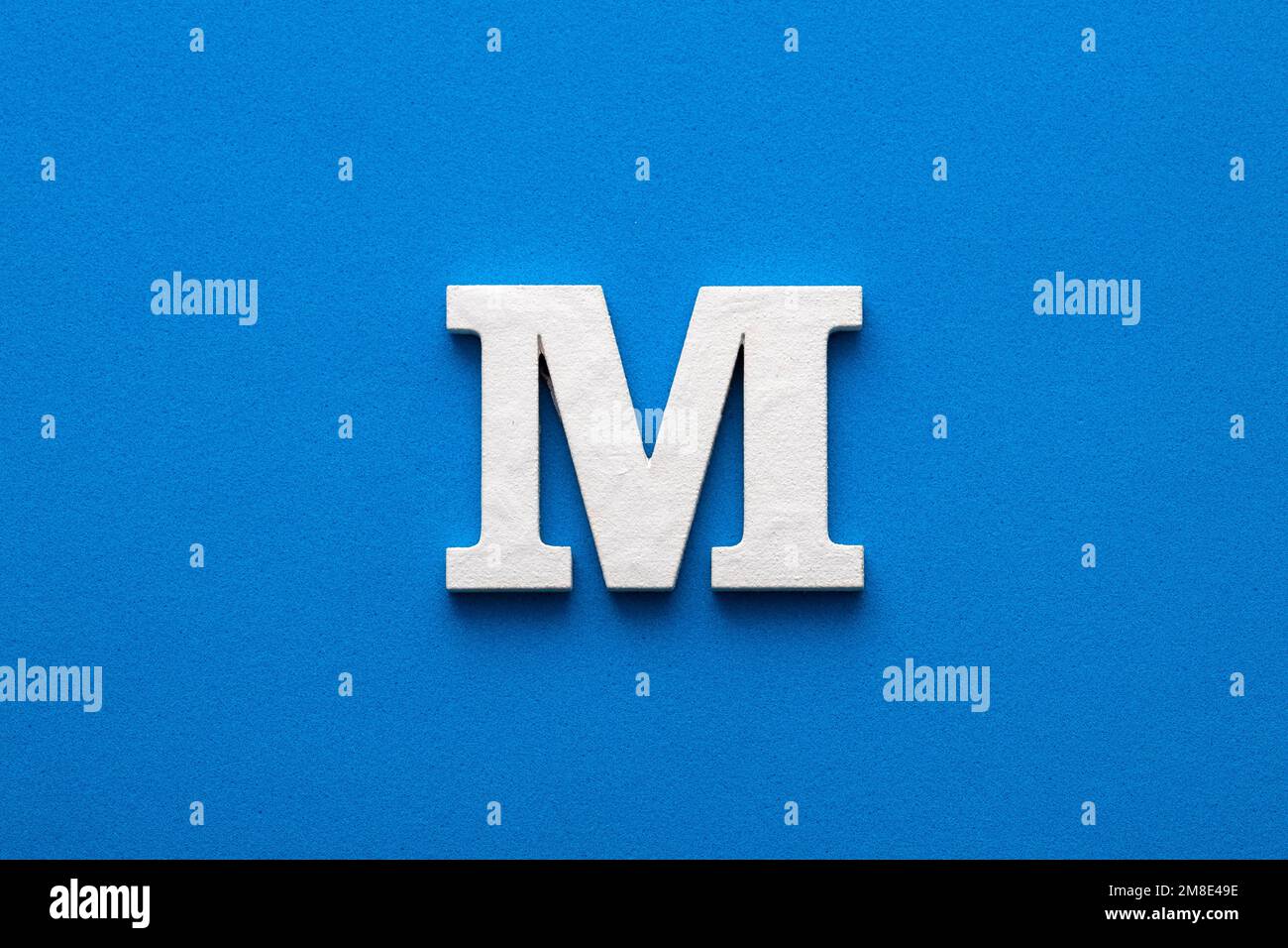 Letter M uppercase - White wood font on blue foamy background Stock ...
