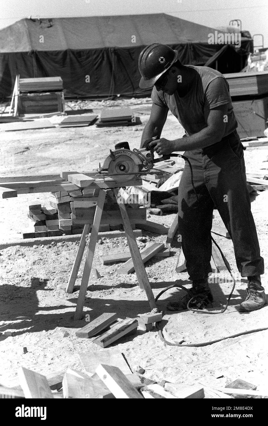 A Seabee from Naval Mobile Construction Battalion 40 (NMCB-40) cuts ...