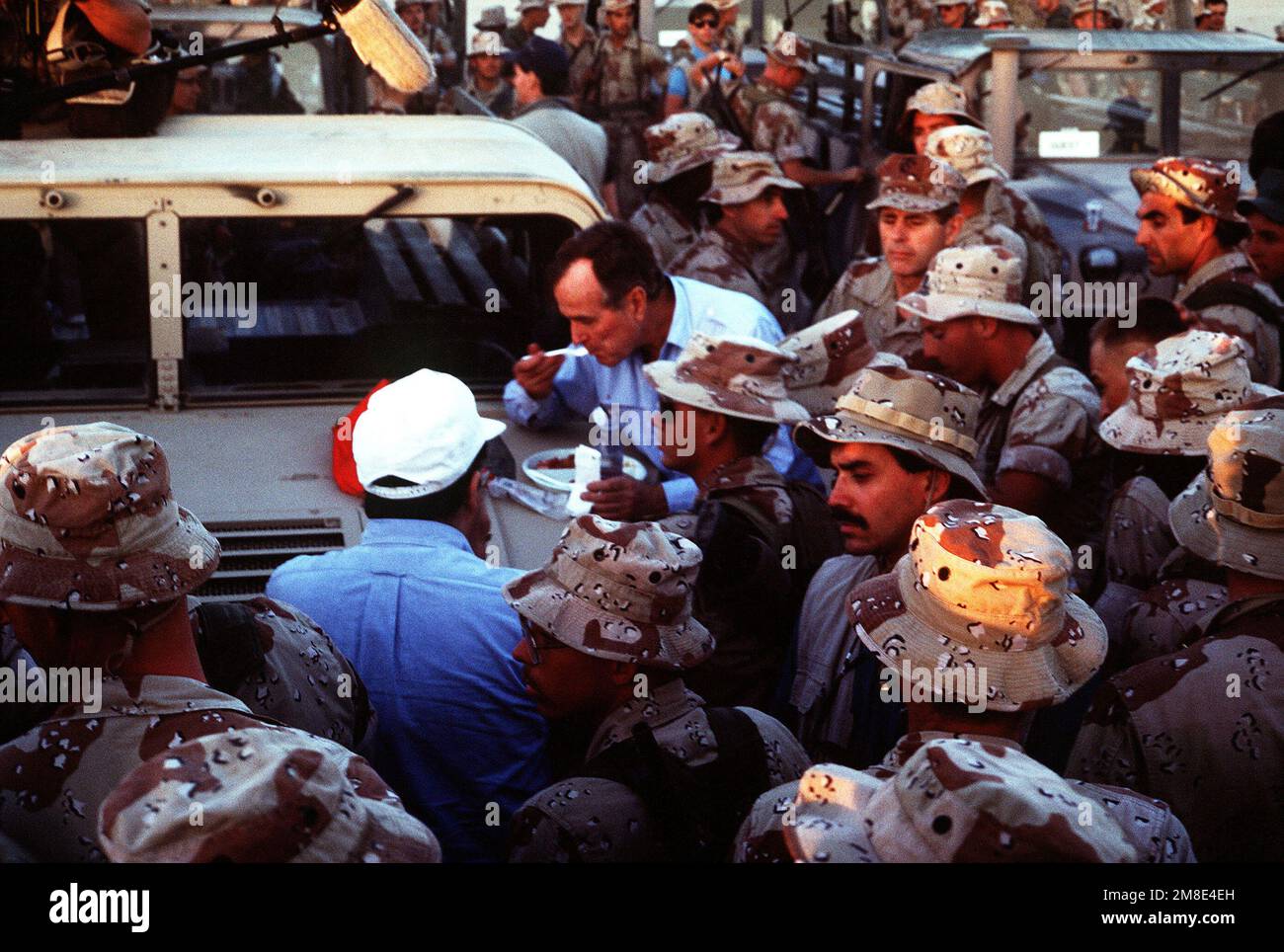 President George Bush eats his Thanksgiving Day dinner on the hood of ...