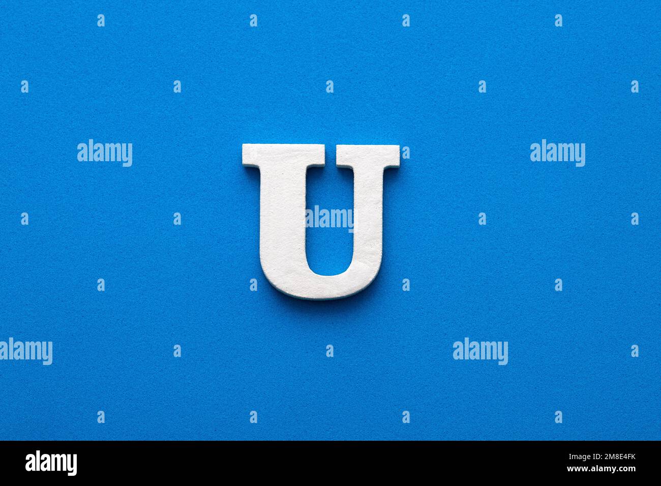 Letter U uppercase - White wood font on blue foamy background Stock ...