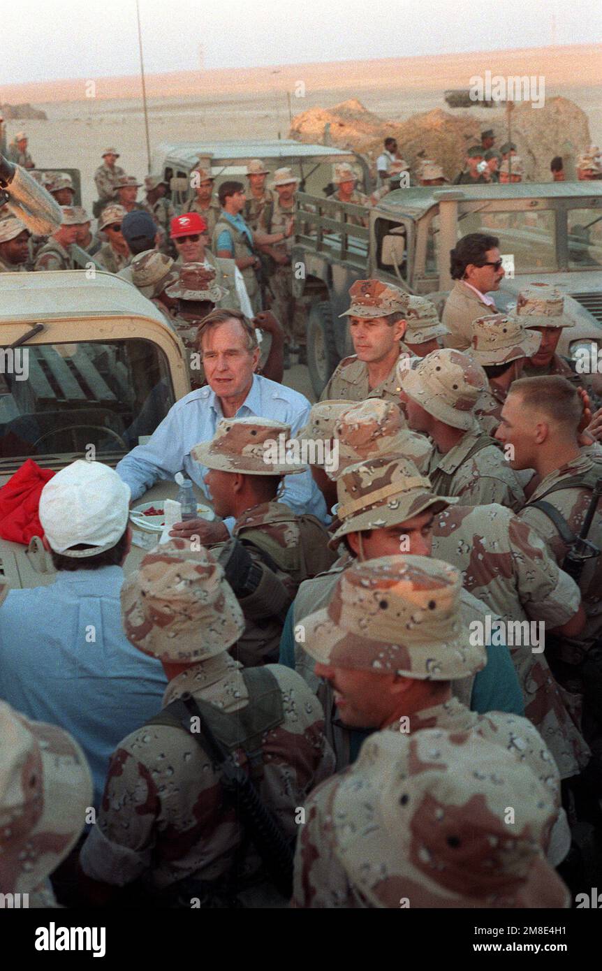President George Bush leans on the hood of a vehicle as he talks to ...