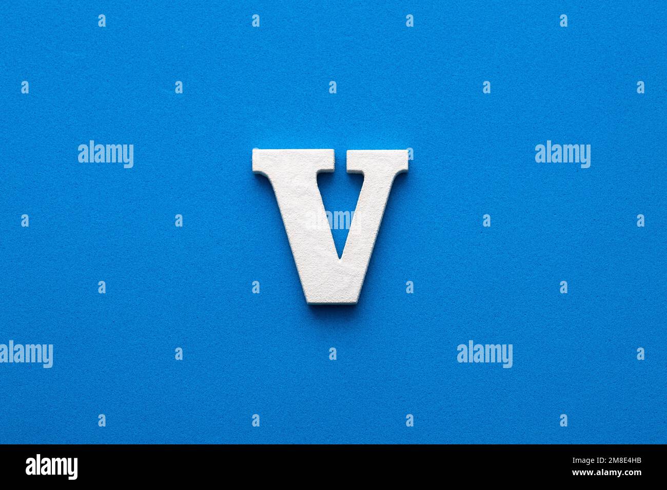 Alphabet letter V - White wooden letter on blue foamy background Stock ...