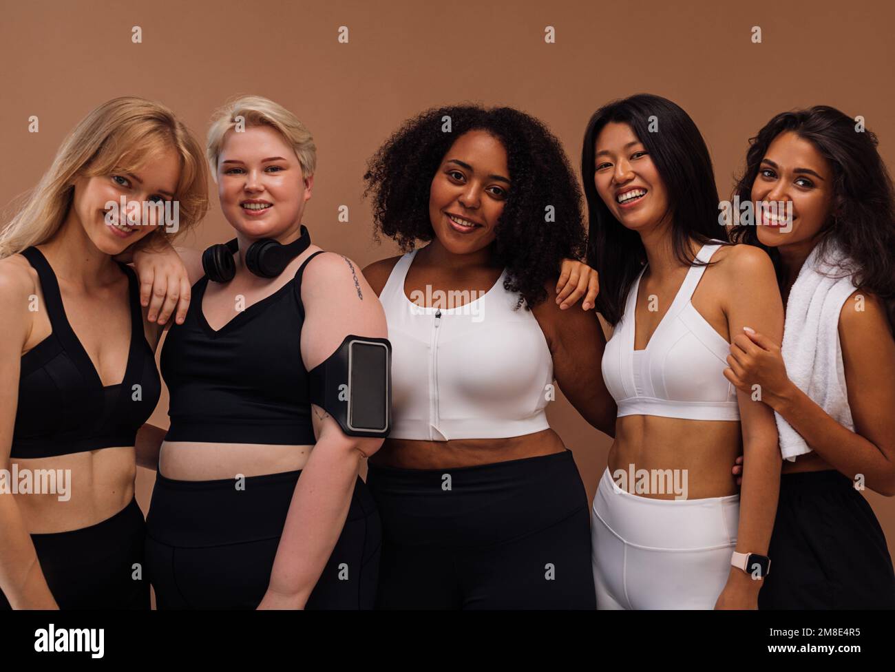 Five smiling women with different body types and skin color posing ...