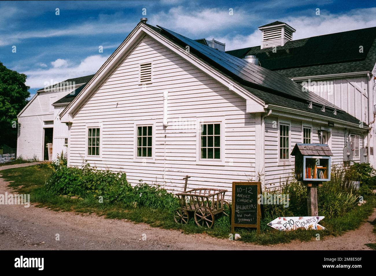 White barns, library box, wood cart at the Codman Community Farms ...