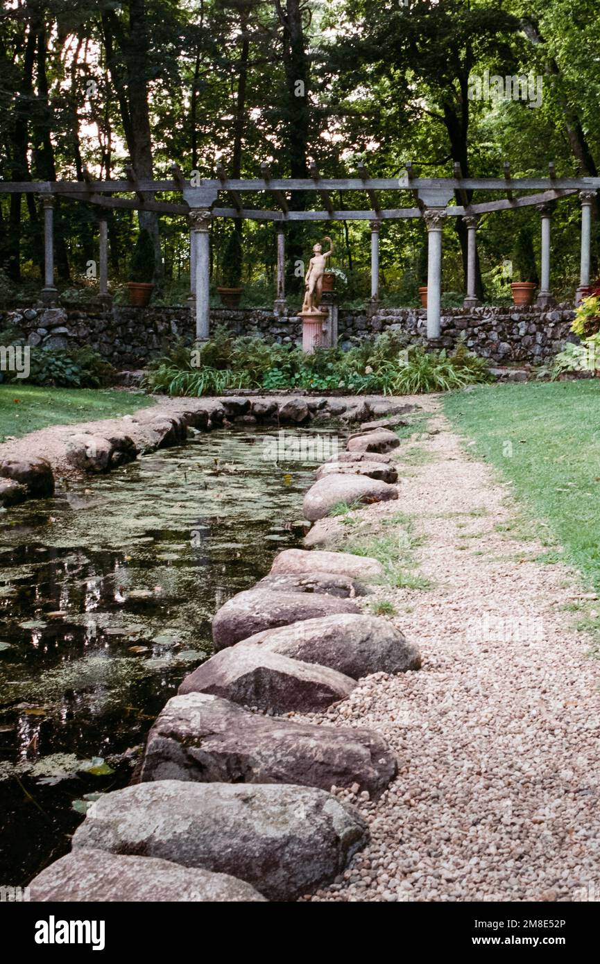A water feature in the Italian garden with a statue and grape trellis ...