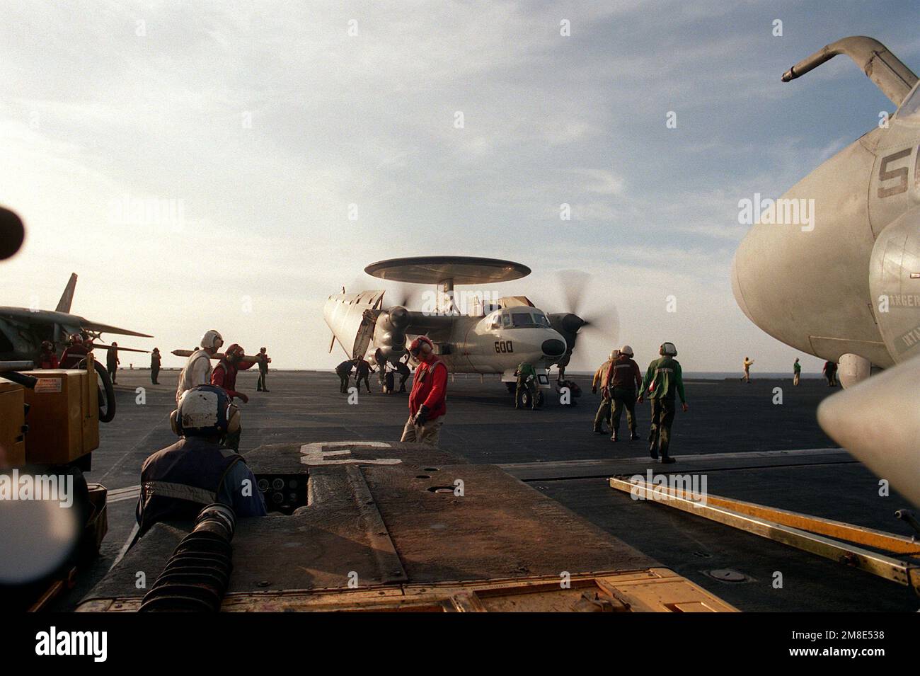 Flight deck crew members conduct a preflight check of an E-2C Hawkeye ...