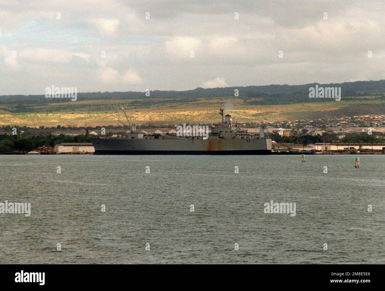 A port beam view of a Military Sealift Command supply ship docked in ...