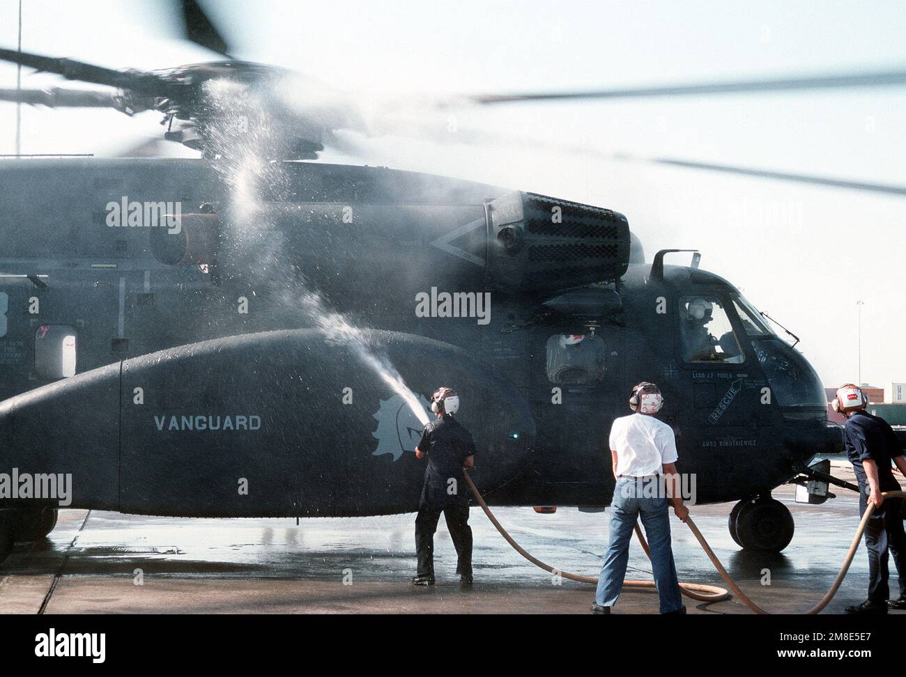Ground crew members hose down a Helicopter Mine Countermeasures ...