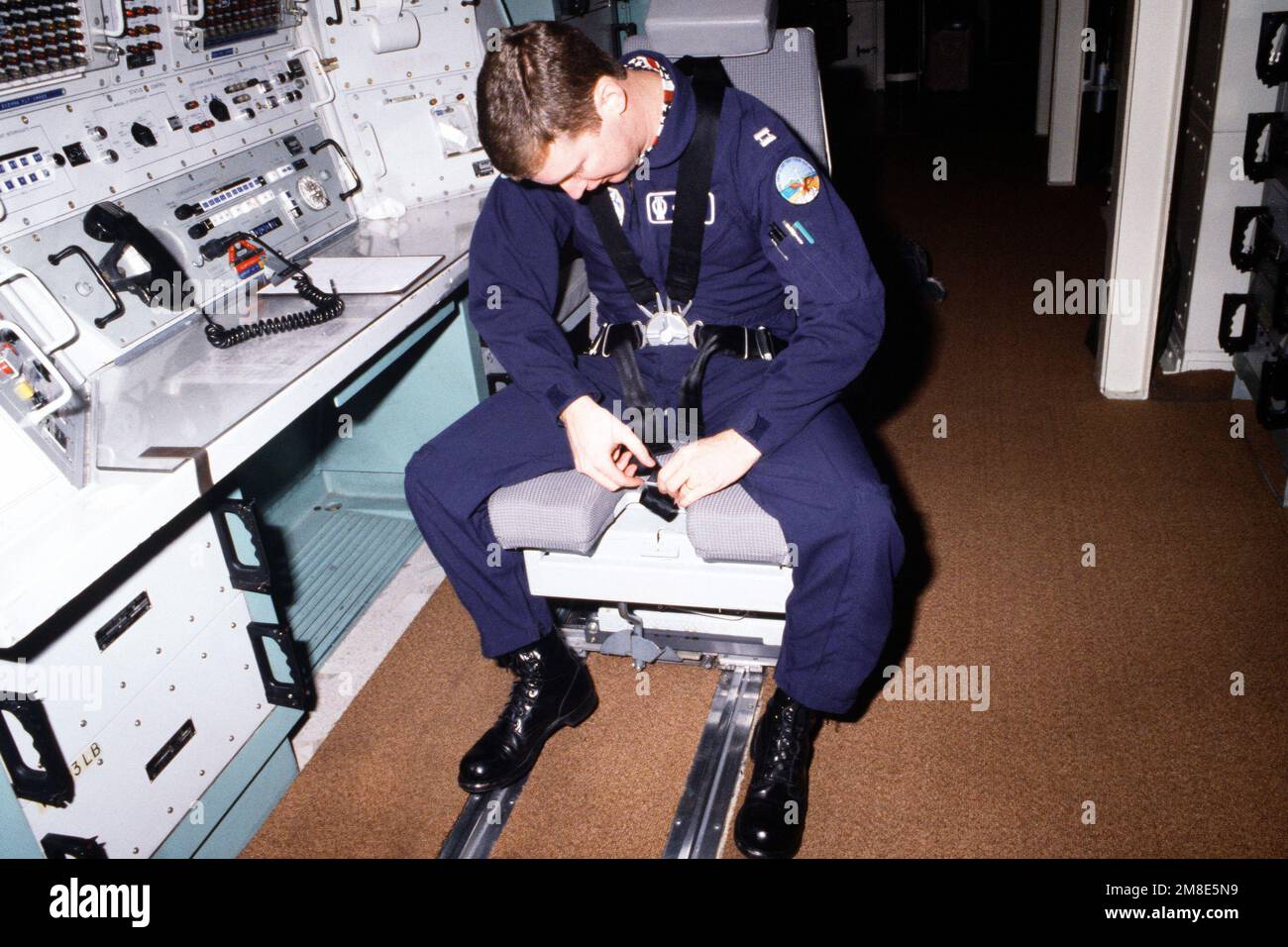 An officer secures himself into the Model 1101 missile crew member ...