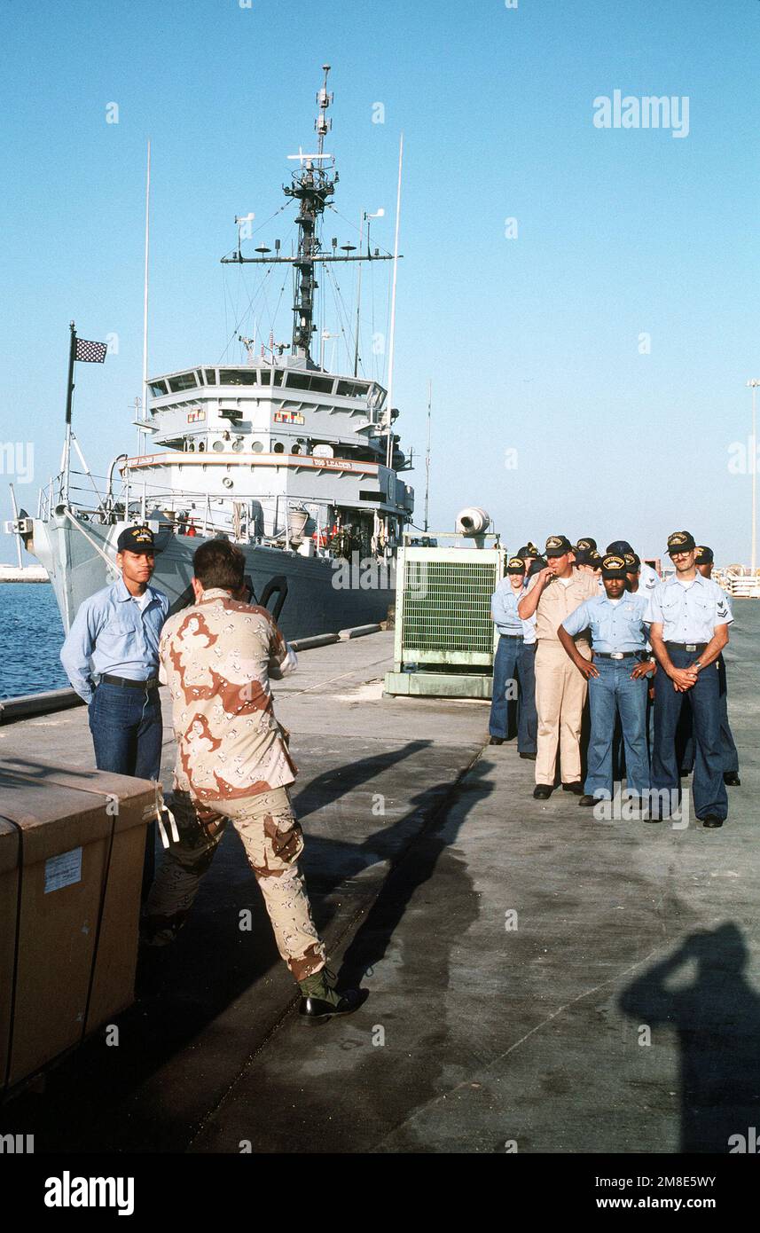 Crew members from the ocean minesweeper USS LEADER (MSO-490) line up to ...