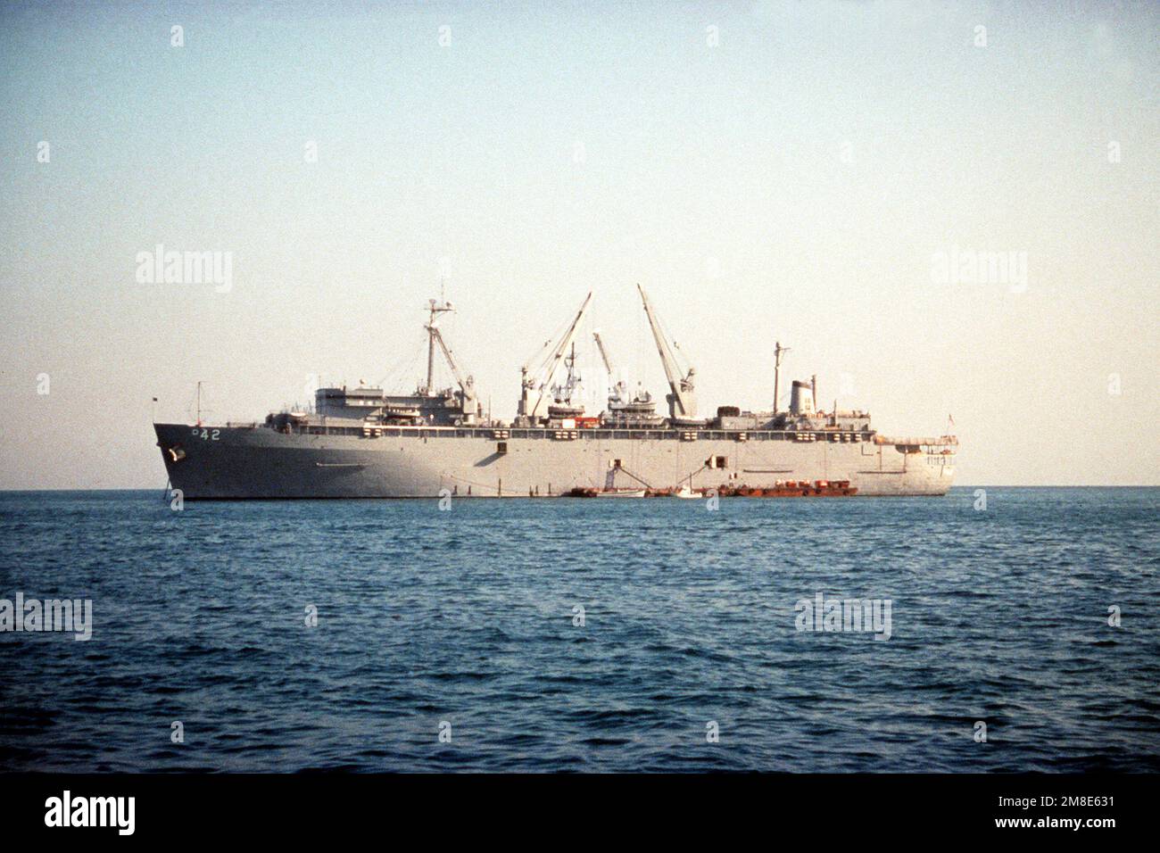 The destroyer tender USS ACADIA (AD-42) lies at anchor with a platform ...