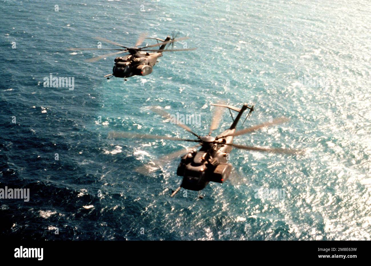 Two Helicopter Mine Countermeasures Squadron 14 (HM-14) MH-53E Sea Dragon helicopters fly over ...