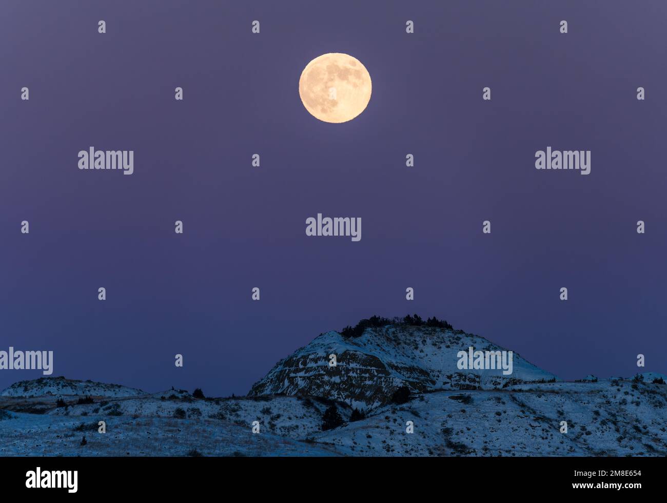 A full moon rising at sunset over a snowy landscape at Theodore ...