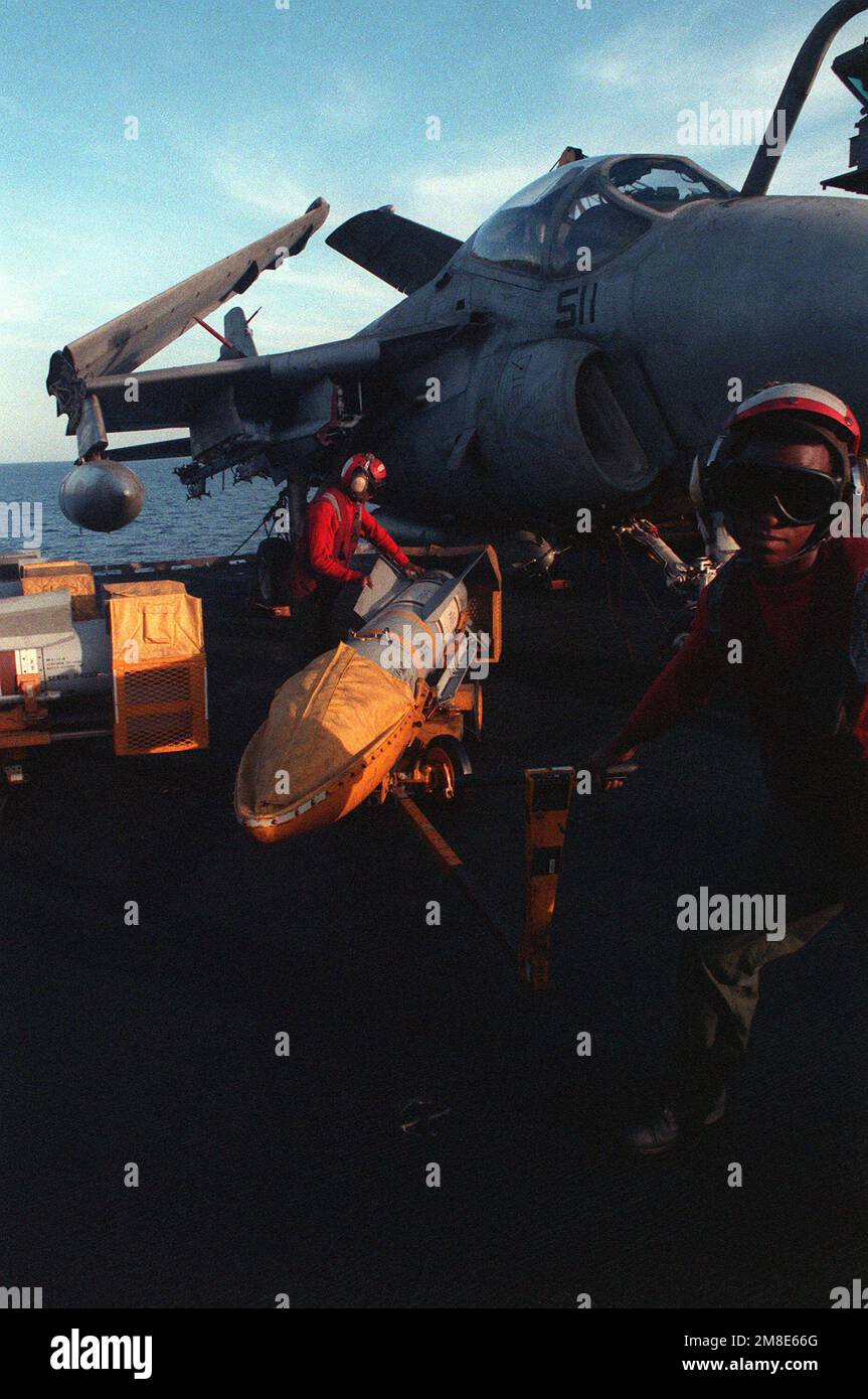 Aviation ordnancemen move an AIM-54C Phoenix missile from beside an ...