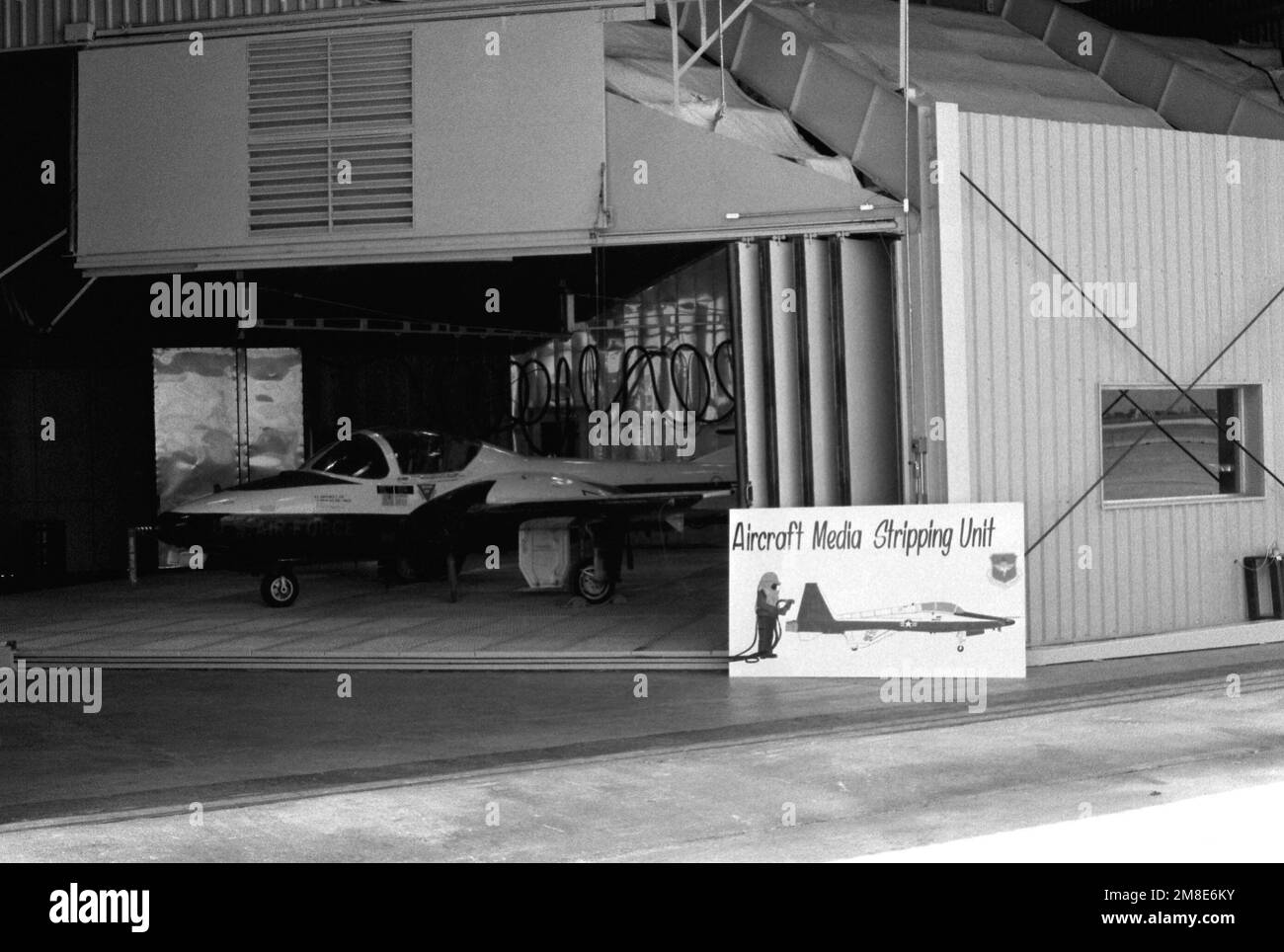 A T-37B Tweet aircraft is parked in a paint booth after receiving a ...