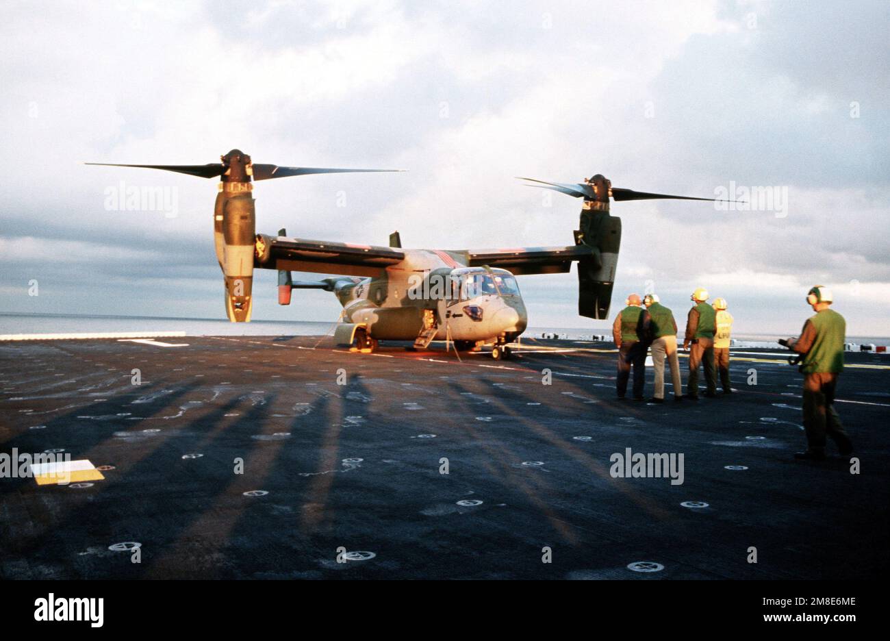 Flight deck personnel stand by as the crew of a V-22A Osprey aircraft ...
