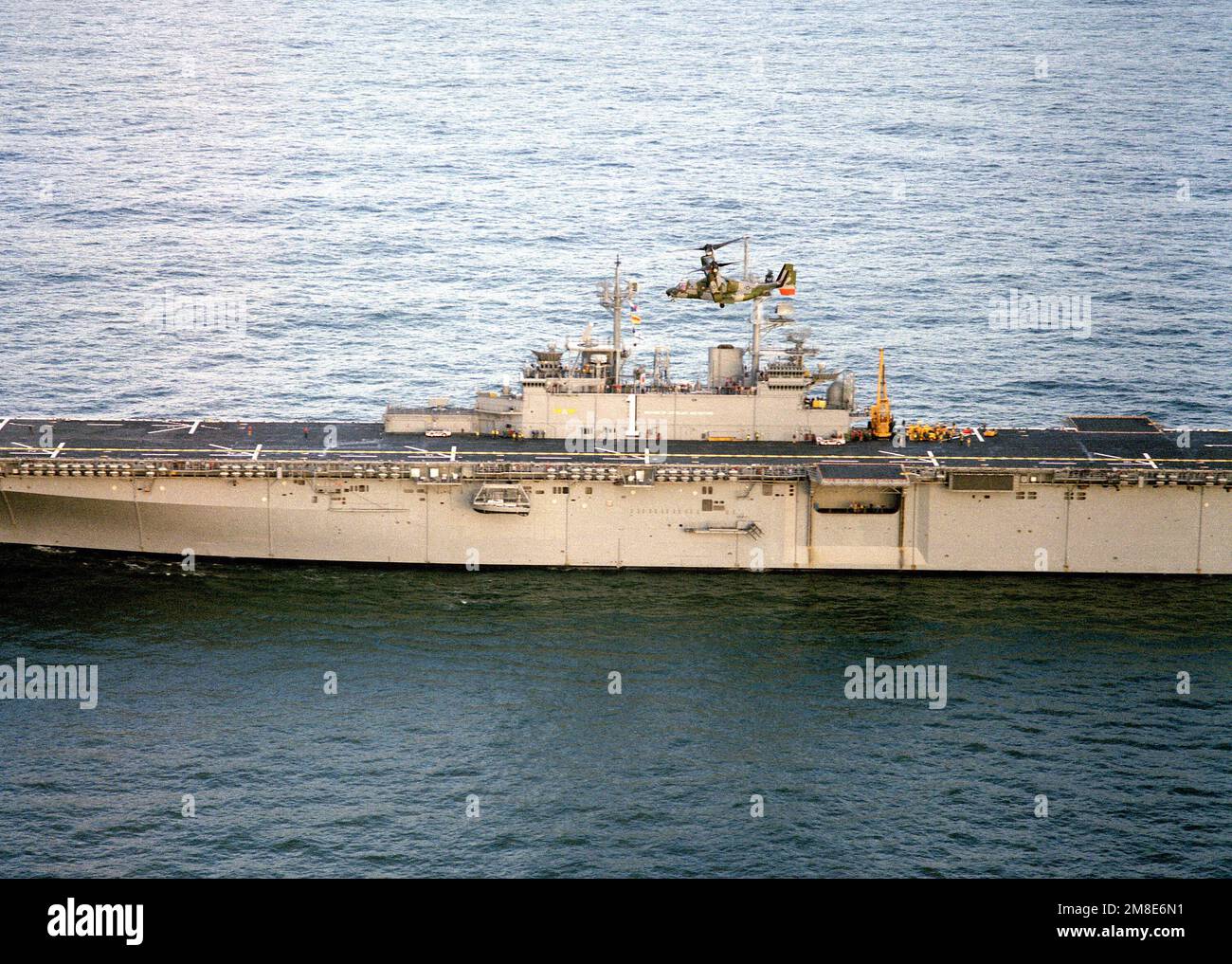 A V-22A Osprey aircraft flies past the amphibious assault ship USS WASP ...