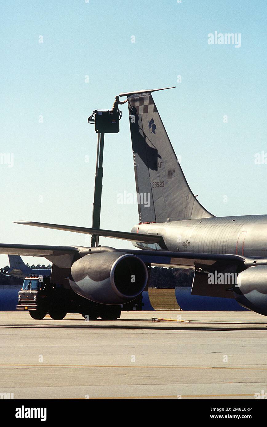 A maintenance crewmen checks part of the vertical stabilizer on a KC-135R Stratotanker aircraft ...