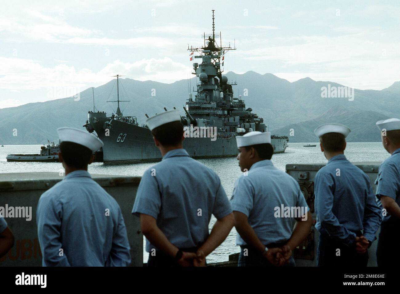 Crew members from another US Navy ship watch as the large harbor tugs ...