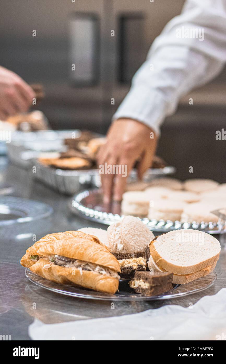 Servers in the kitchen preparing finger foods for a tea party Stock ...