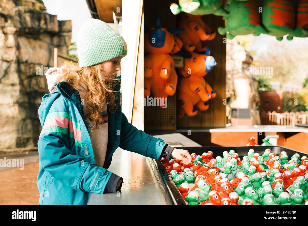 Child playing games at an amusement park trying to win Stock Photo - Alamy