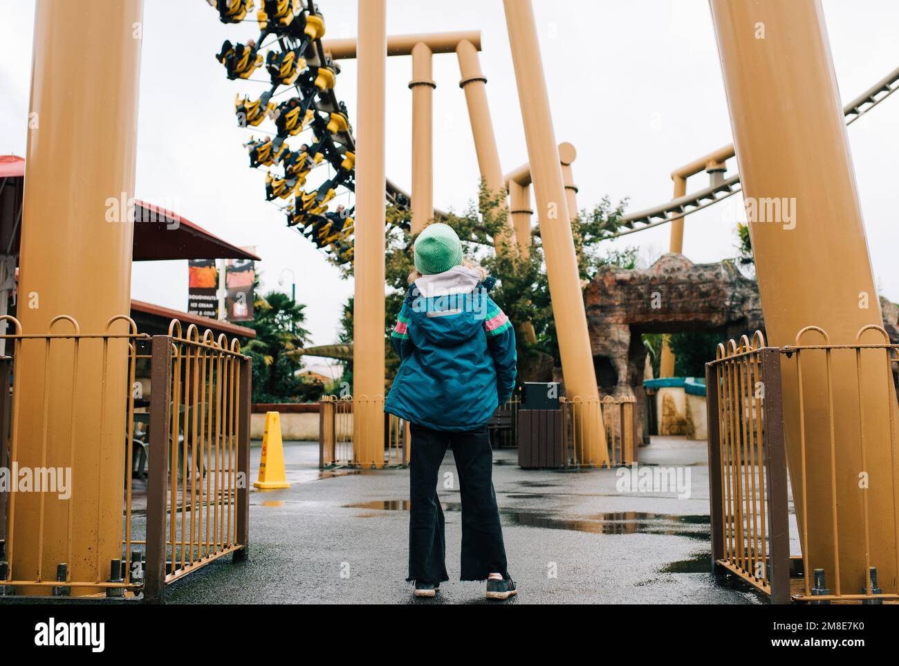 child looking up at a rollercoaster ride in an amusement park Stock ...