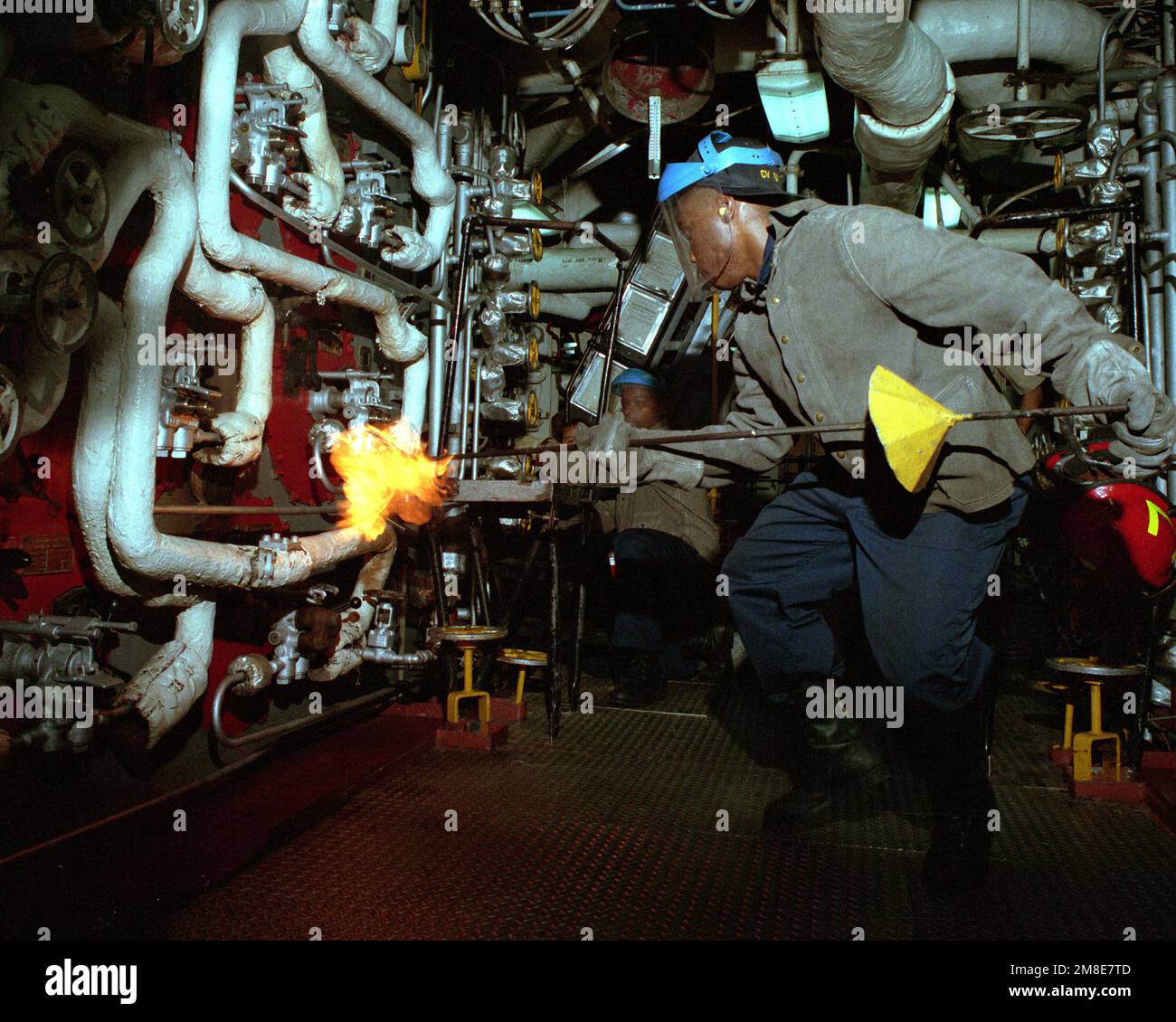 Boiler Technician Fireman Clark Roderick assists in lighting off one of ...