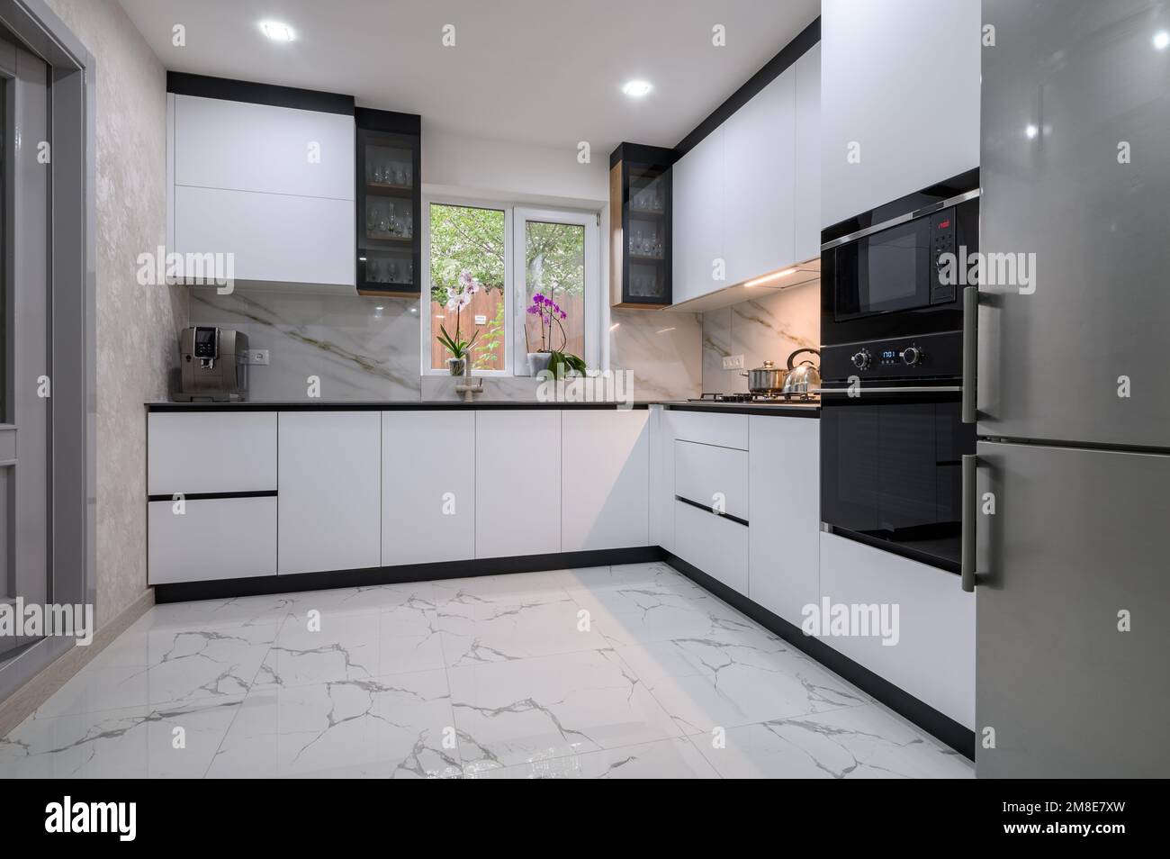 A renovated studio apartment features a bright, white kitchen Stock ... A renovated studio apartment features a bright, white kitchen Stock ...
