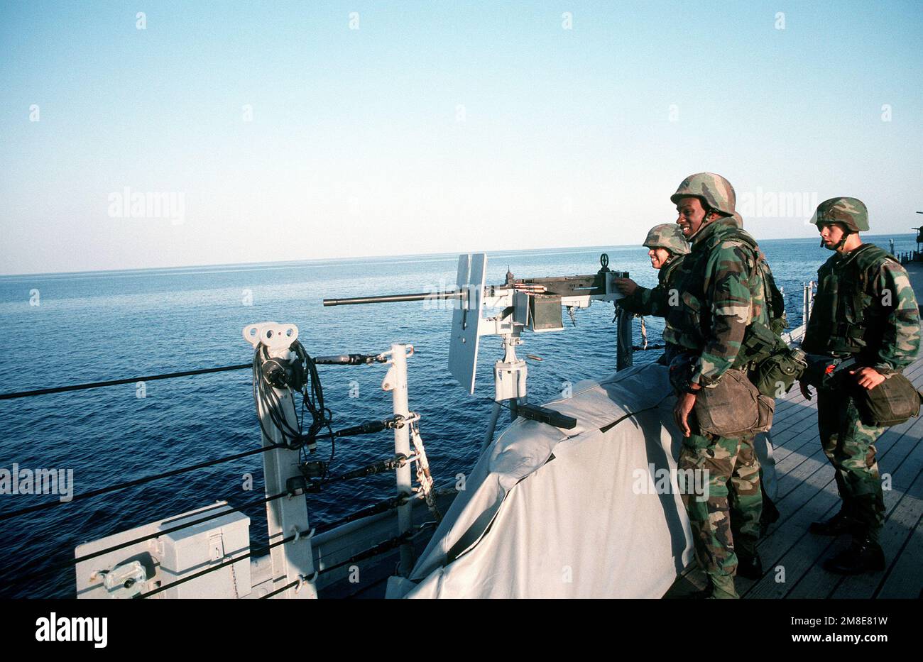Members of the ship's Marine detachment prepare to fire an M-2 .50 ...