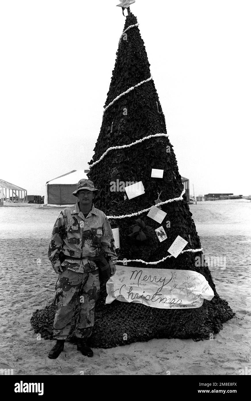 A Marine captain poses in front of a 1ST Marine Division Christmas tree ...