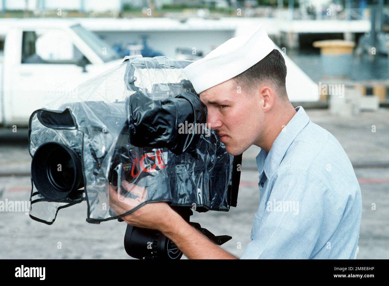 A photographer's mate from the battleship USS MISSOURI (BB 63) uses a ...