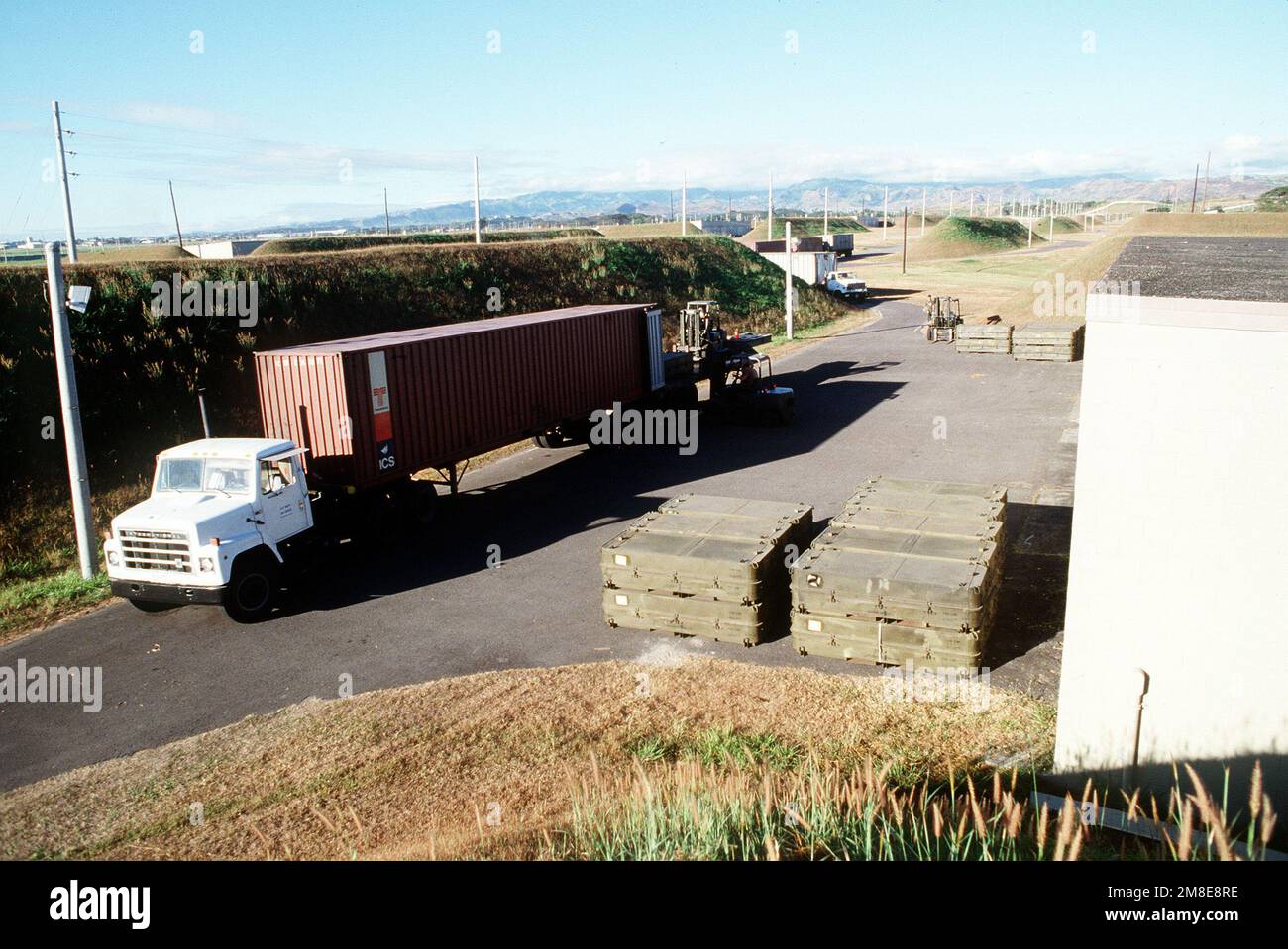 A forklift is used to load cases of CBU-52 bombs into a trailer. The ...