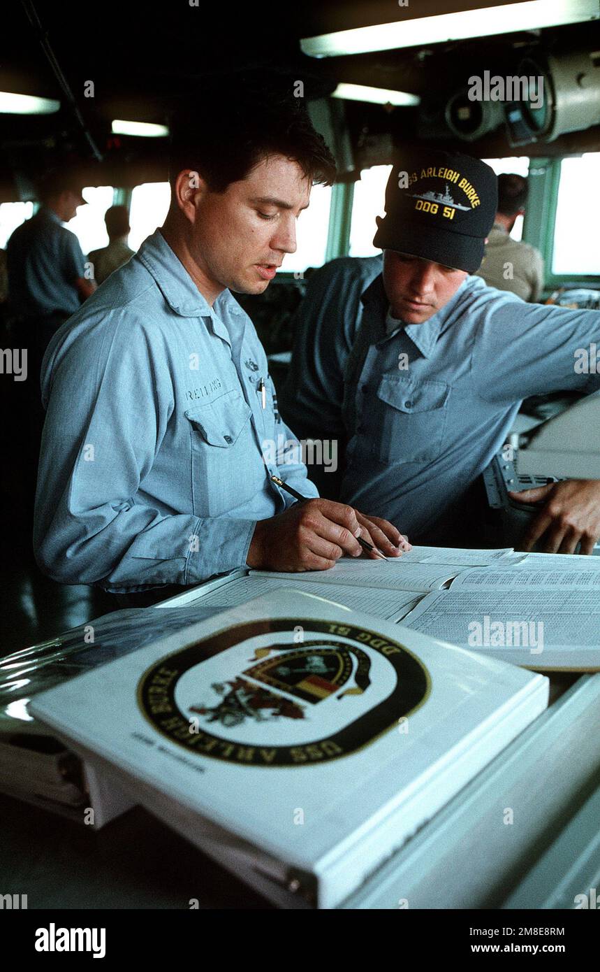 The quartermaster makes a log entry on the bridge of the guided missile ...