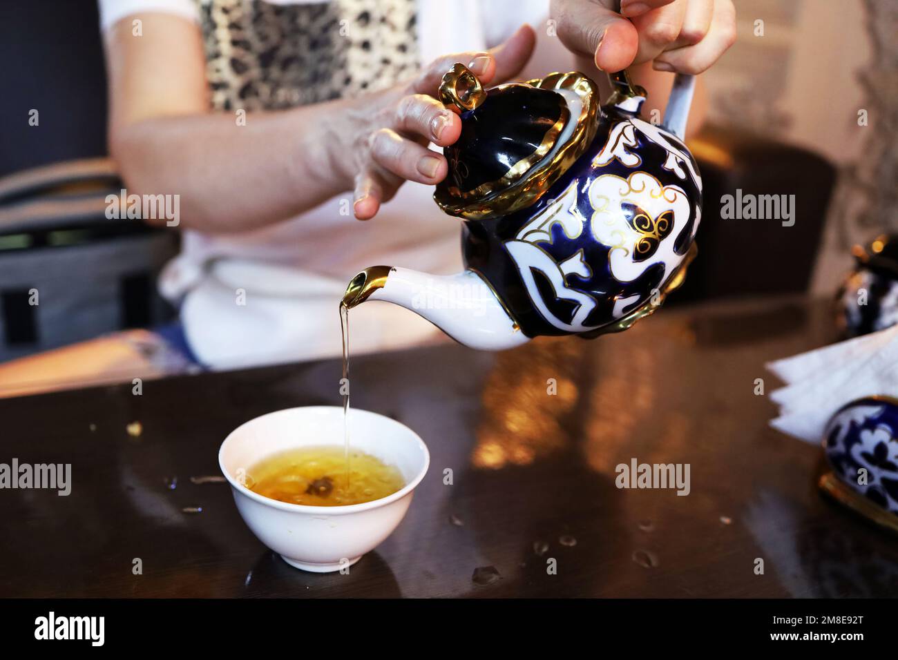 A woman pours tea into a cup in an Uzbek coffee shop Stock Photo - Alamy