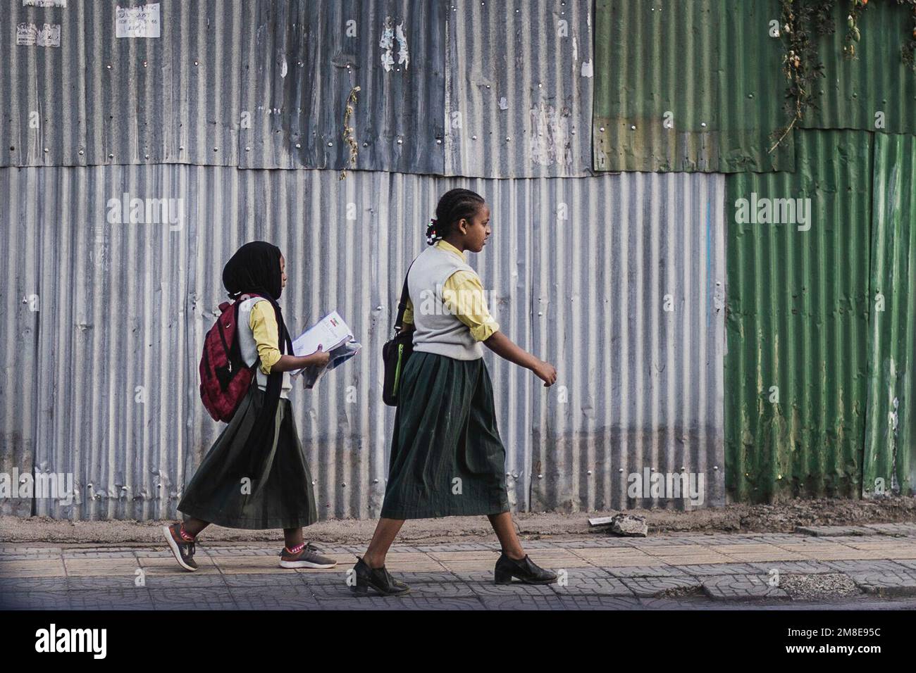 Two students walk on a sidewalk in Addis Ababa on January 13, 2023 ...