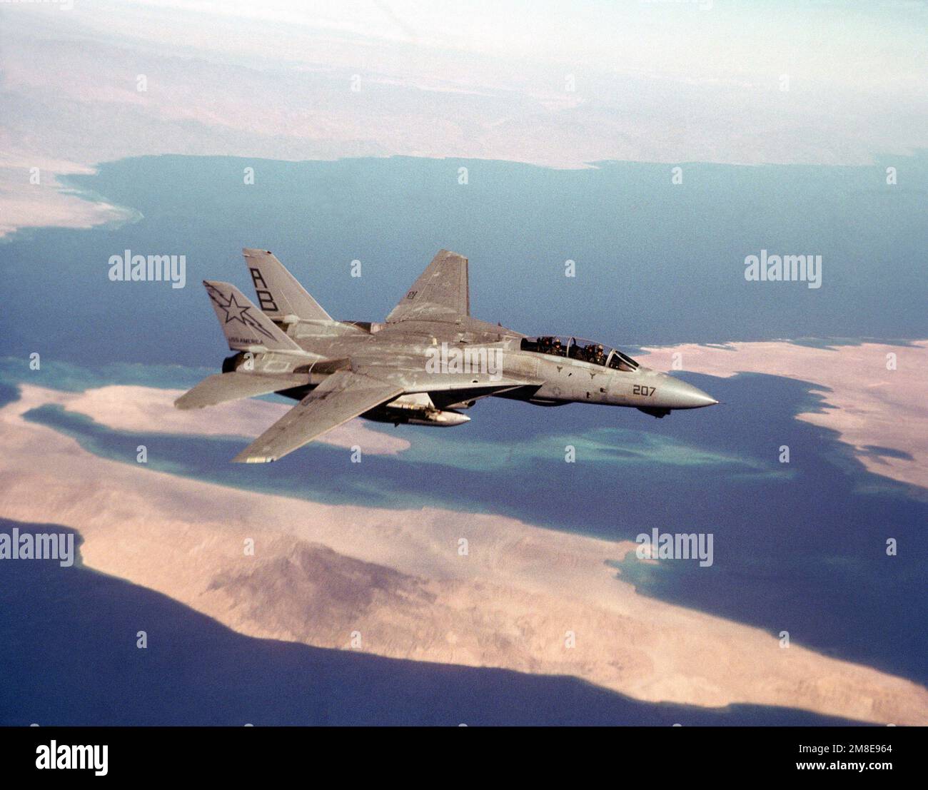 A Fighter Squadron 33 (VF-33) F-14A Tomcat aircraft flies a combat air ...