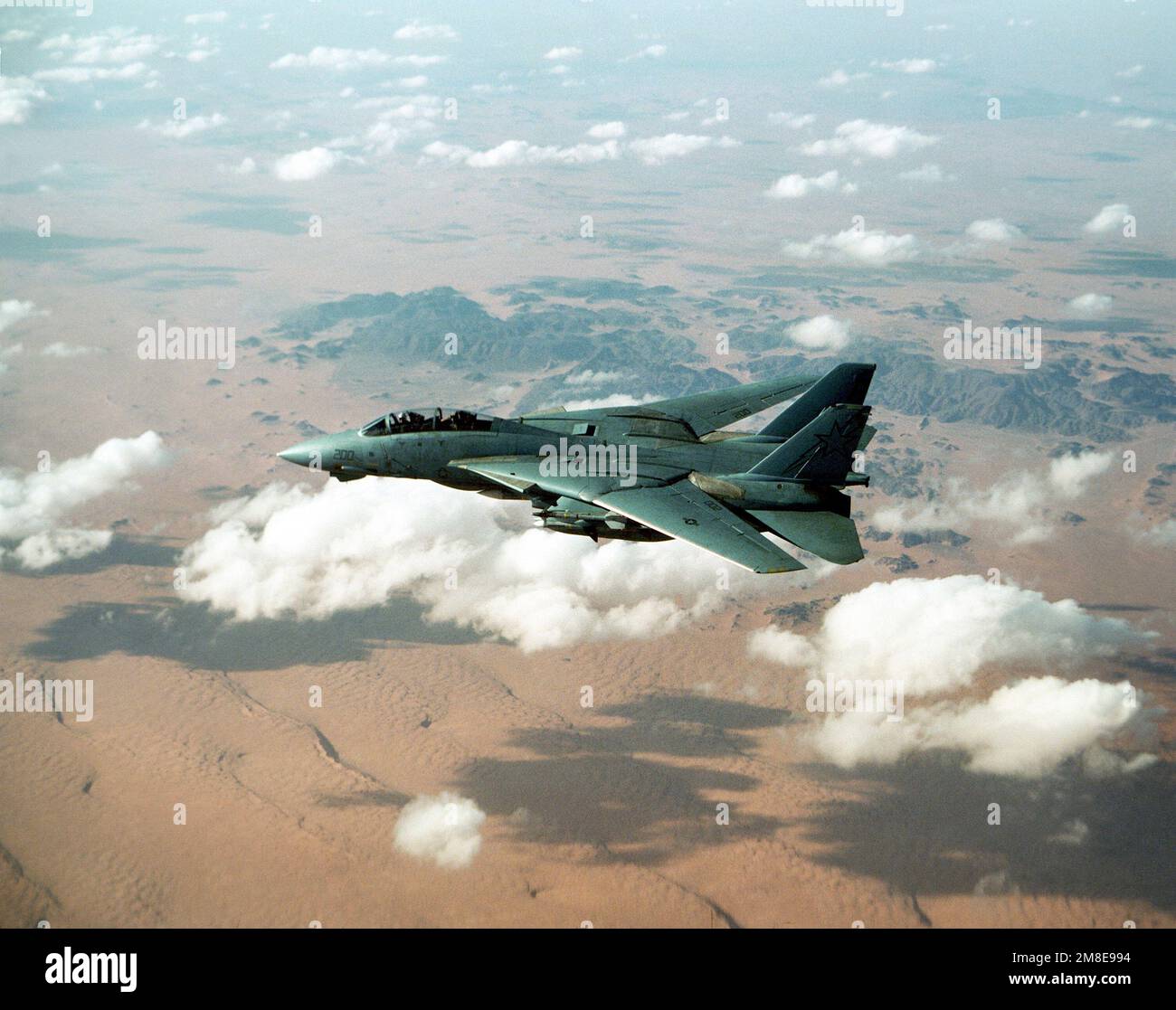 A Fighter Squadron 33 (VF-33) F-14A Tomcat aircraft passes over the ...