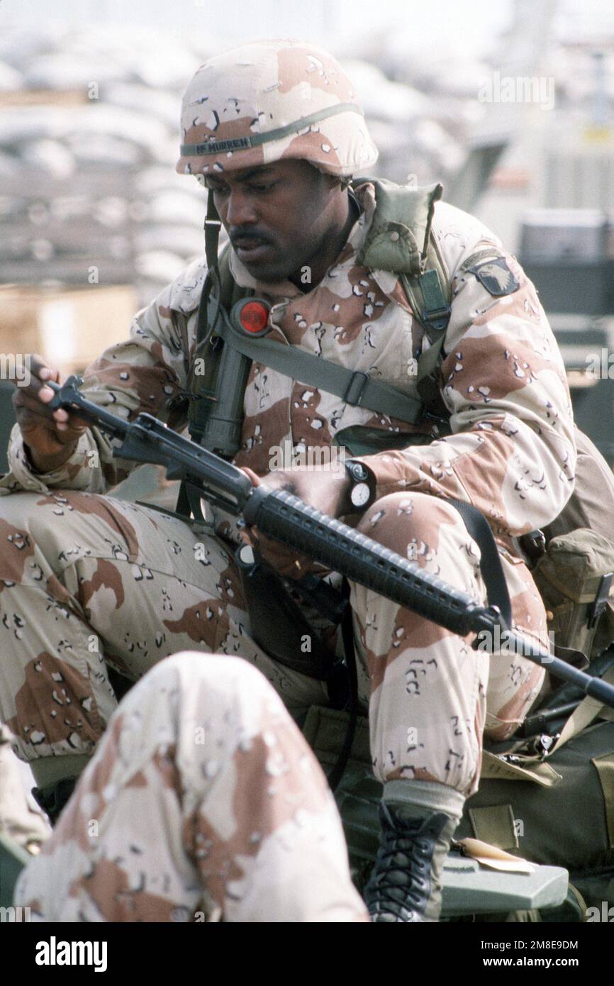 A member of the 101st Airborne Division cleans an M-16A2 rifle while ...