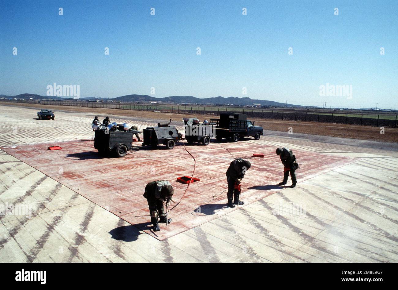 Wearing full nuclear-biological-chemical (NBC) protective gear, three ...