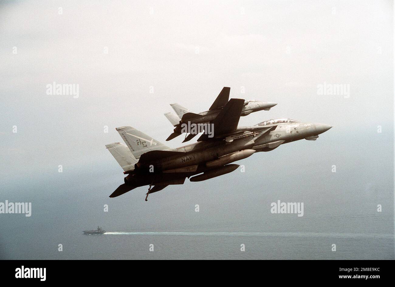 Two Fighter Squadron 32 (VF-32) F-14A Tomcat aircraft bank toward the ...